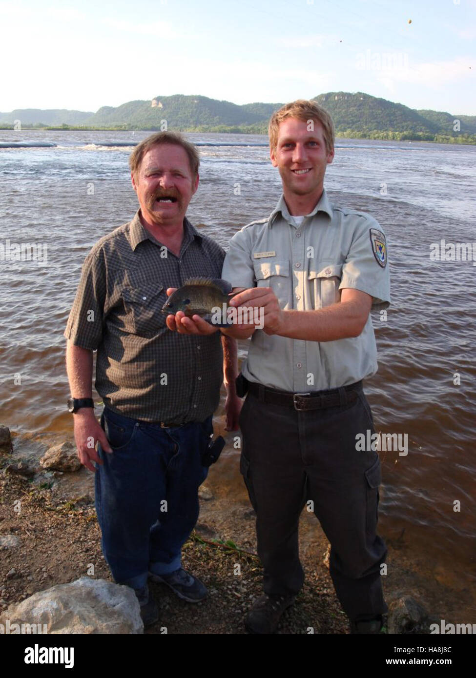 Kyle Slifka holds a fish as part of Project COMPASS, a U.S. Fish and ...