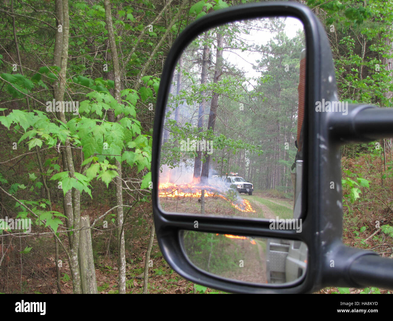 A reflection of a fire in the rearview mirror of a vehicle, symbolizing ...