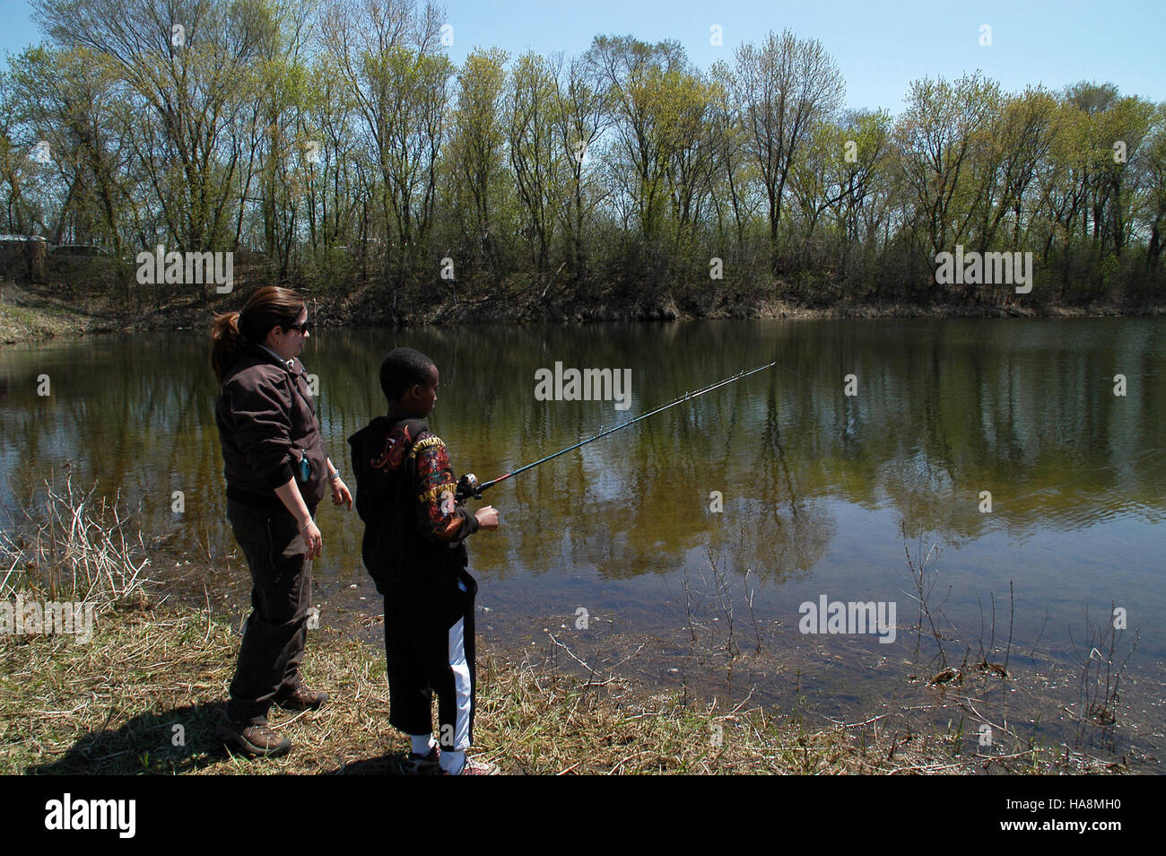 A child fishes with guidance from Laura Bonneau, Visitor Services ...