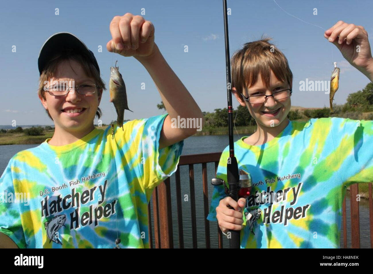 Two hatchery staff proudly display their catch on a fishing day in a ...