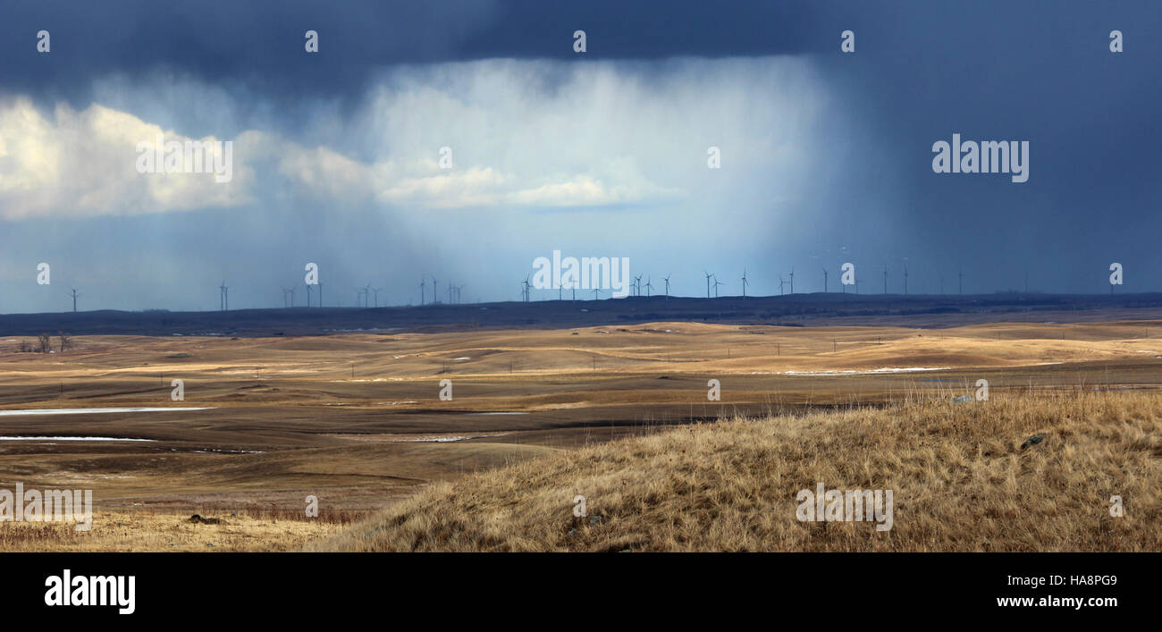 A photograph of wind turbines in the midst of a rainstorm, showcasing ...