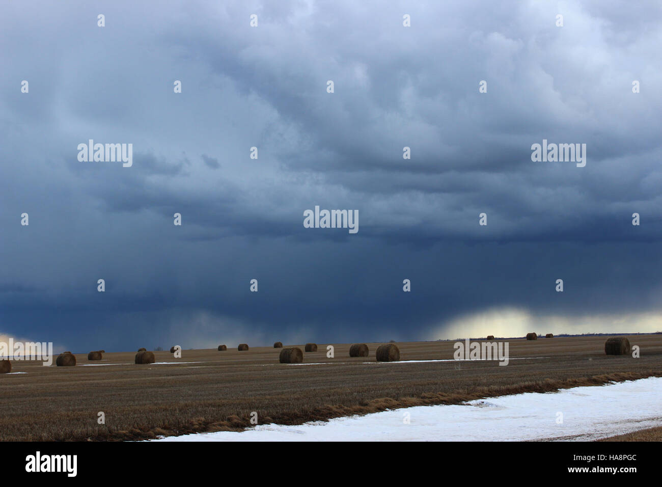 This image captures a dramatic scene of showers falling over a baled ...