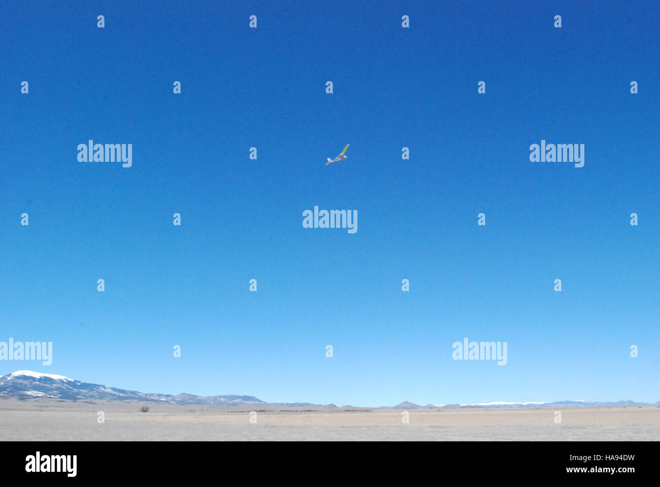 This image depicts an unmanned aircraft system (UAS) in flight over a ...