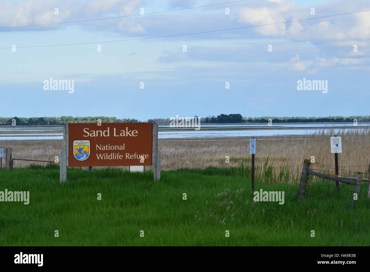 A photograph capturing the sign and surrounding scenery of Sand Lake ...