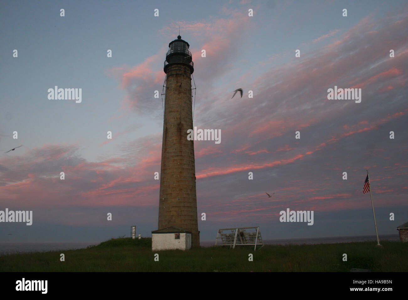 A lighthouse at sunset, located in a national park, stands as a beacon ...