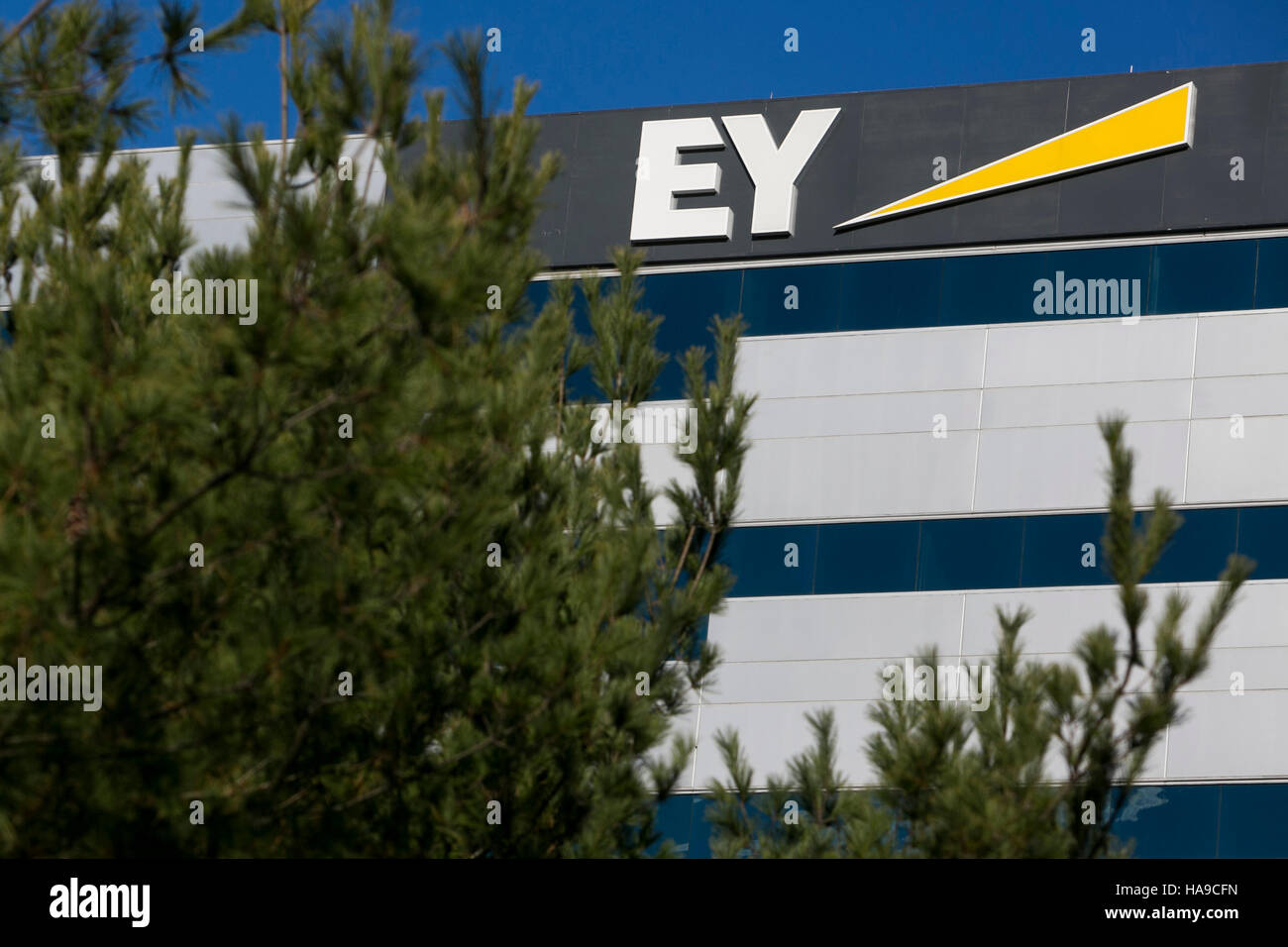 A logo sign outside of a facility occupied by EY (Ernst & Young) in ...