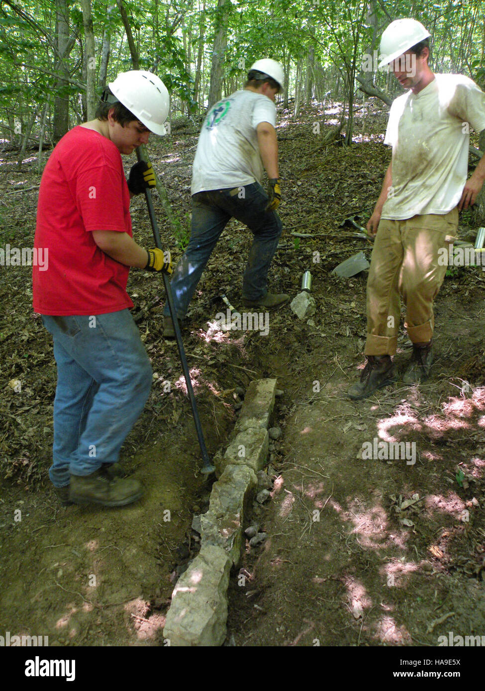 The image shows the construction of a water bar in a national park, an ...