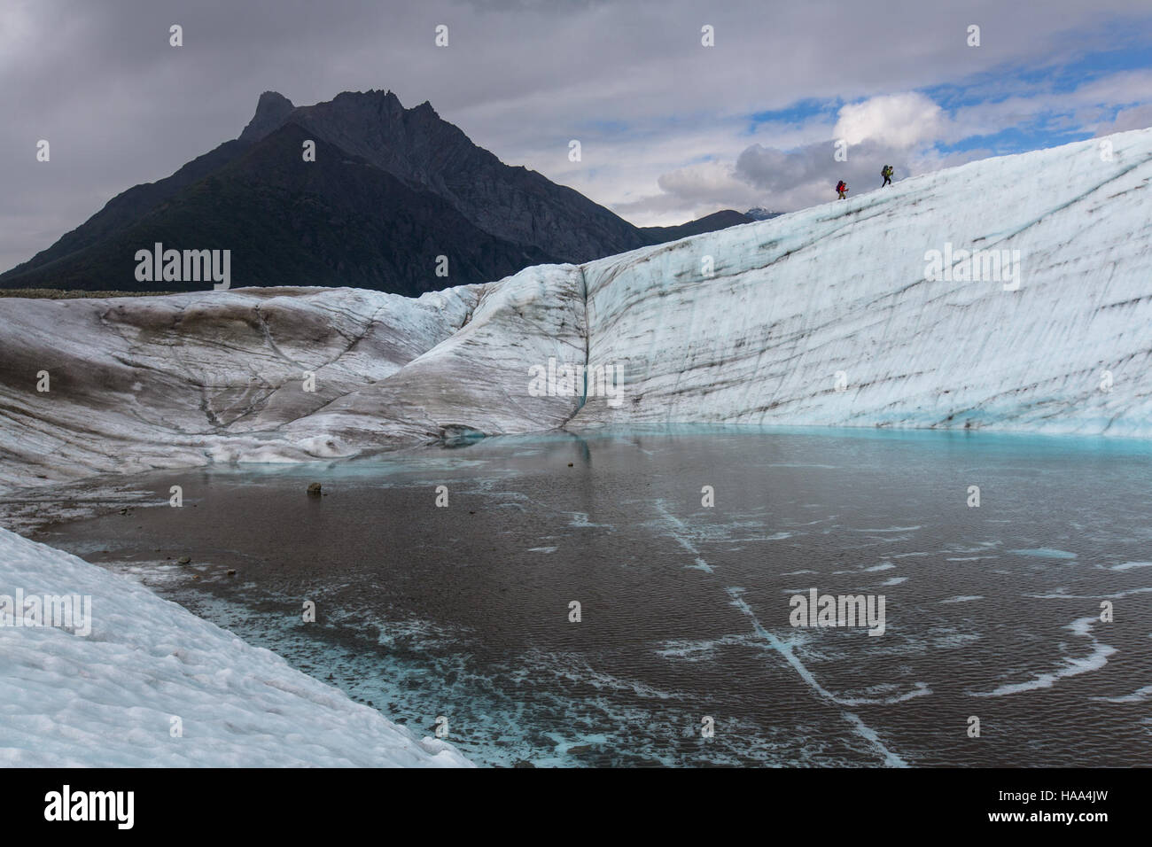 Backpackers explore the Root Glacier in Alaska, navigating its rugged ...