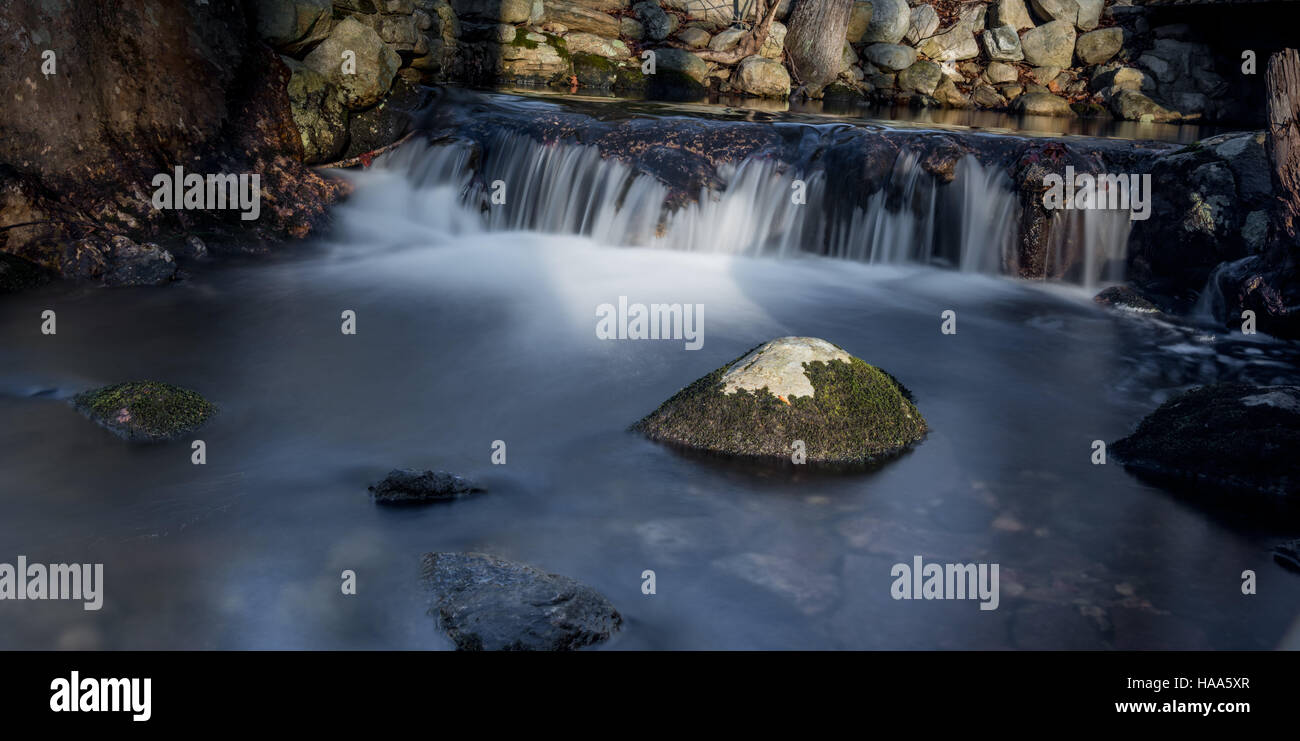 Slow shutter brook with solitary rock Stock Photo - Alamy