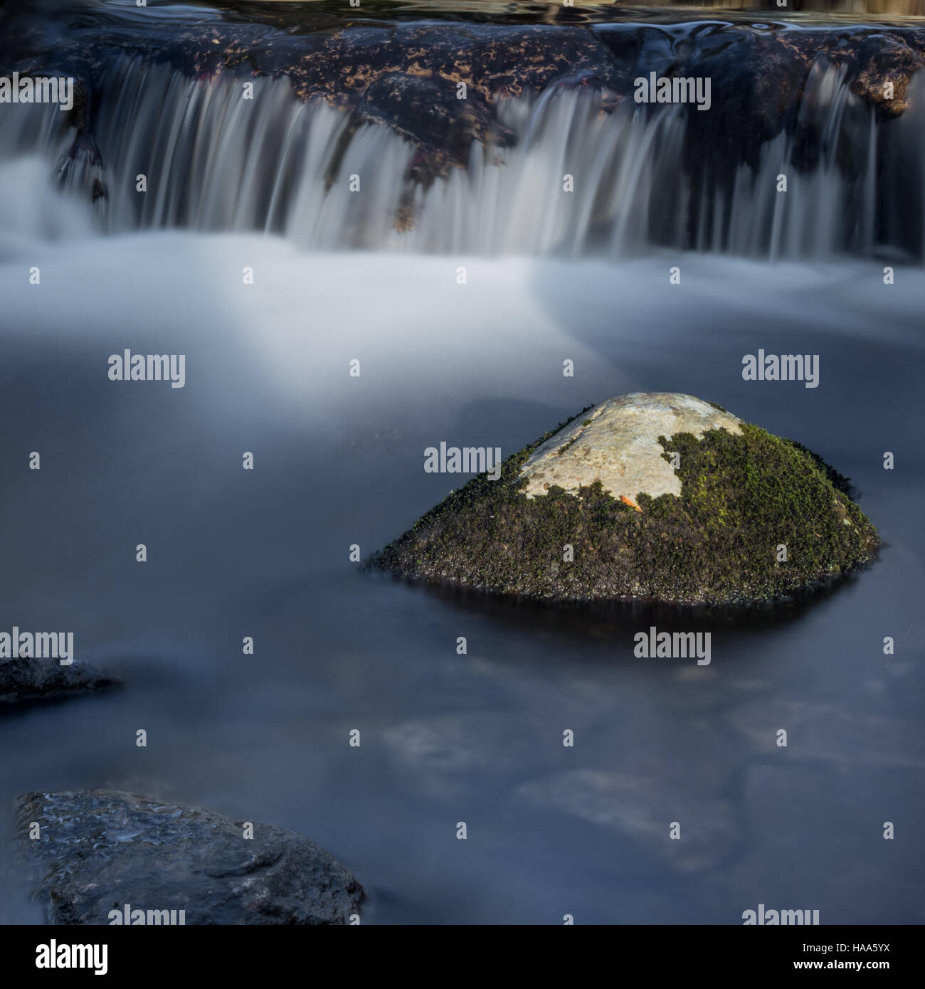 Slow shutter brook with solitary rock Stock Photo - Alamy