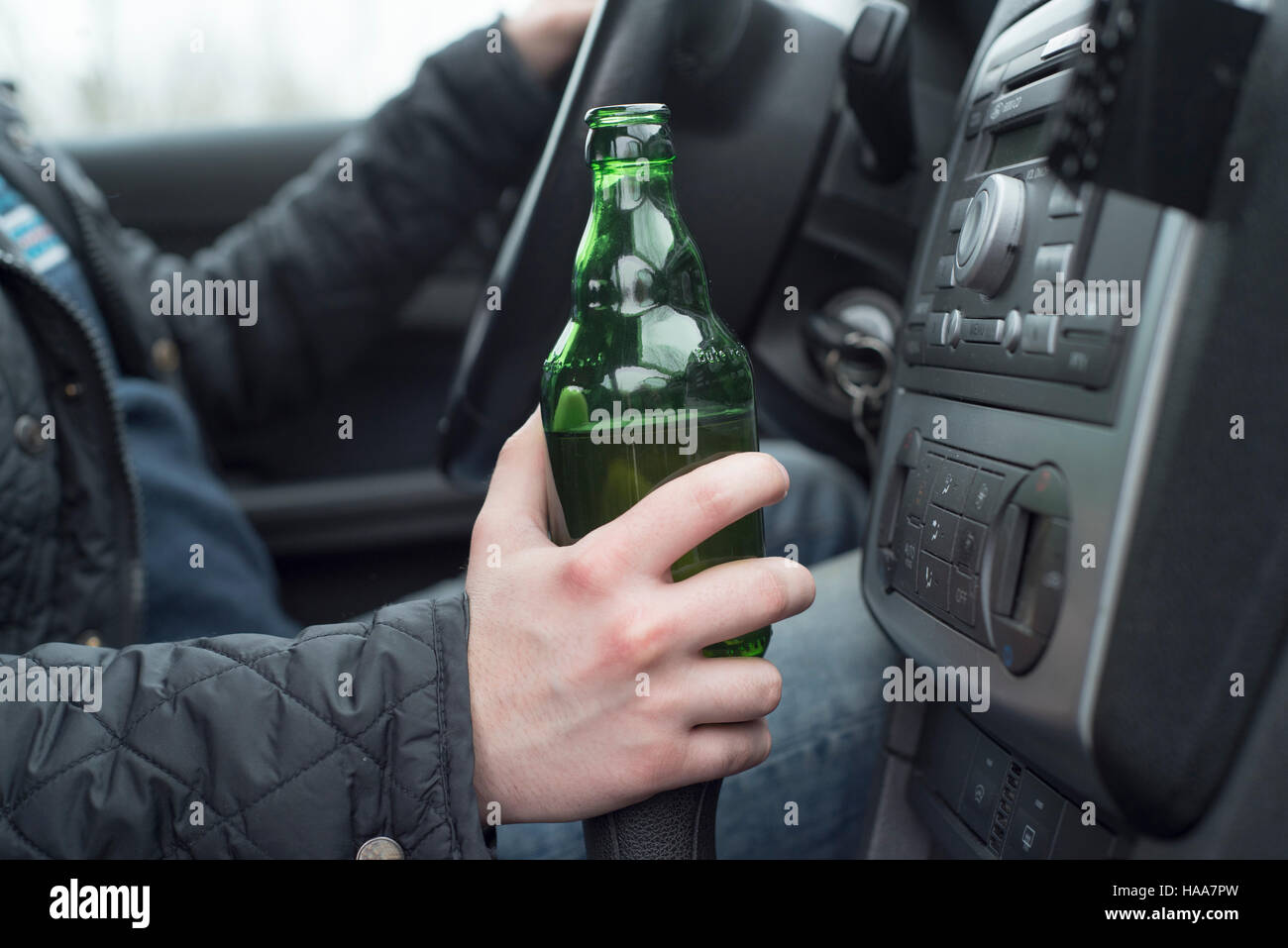 Young man driving his car while drinking alcohol Stock Photo - Alamy