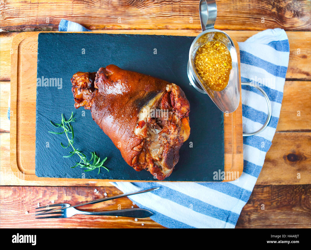 Roasted pork leg (rulka) served with garlic sauce on the wooden table ...