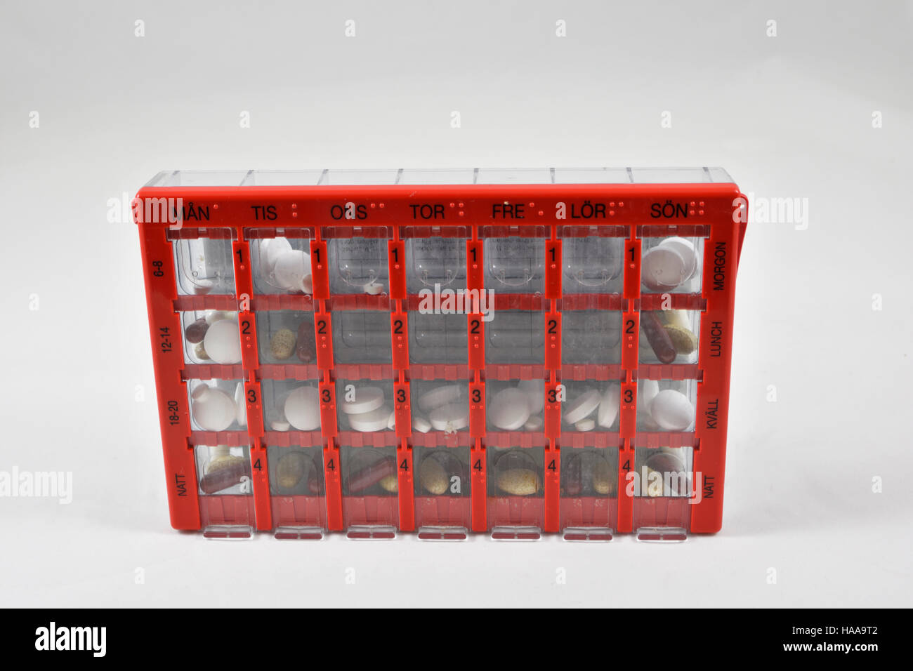 Red dosage box for one week four times each day and with some pills ...