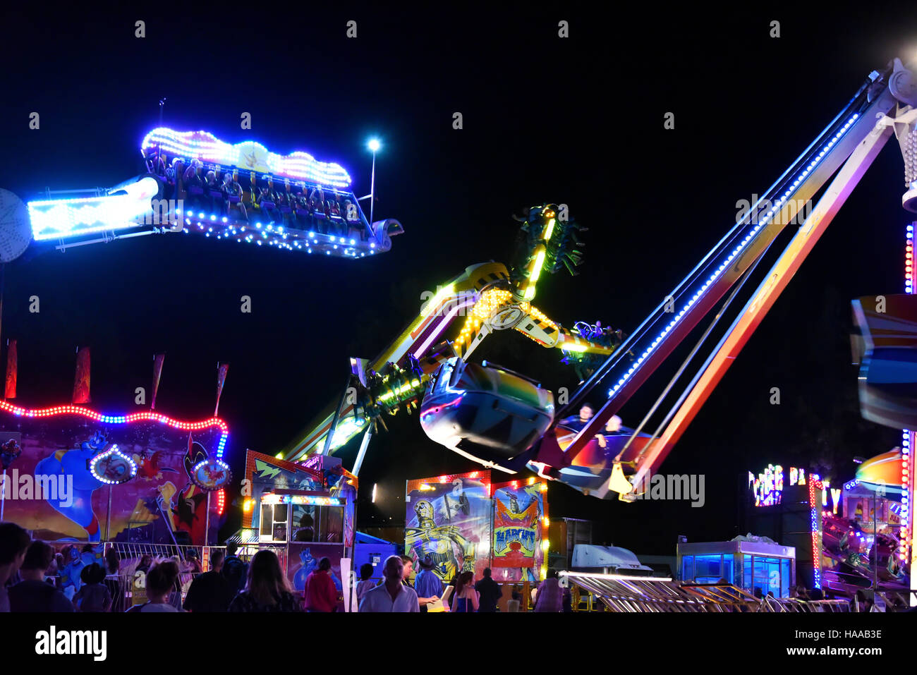 nightime fairground thrill ride carrying passengers upside down high ...