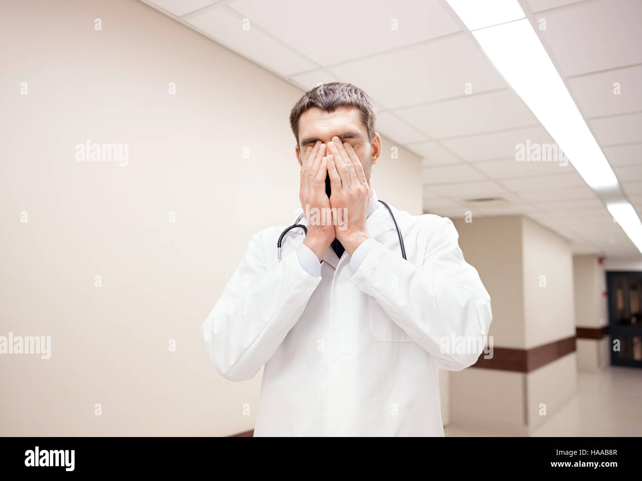 sad or crying male doctor at hospital corridor Stock Photo - Alamy