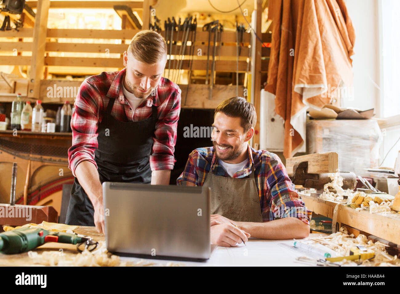 carpenters with laptop and blueprint at workshop Stock Photo - Alamy