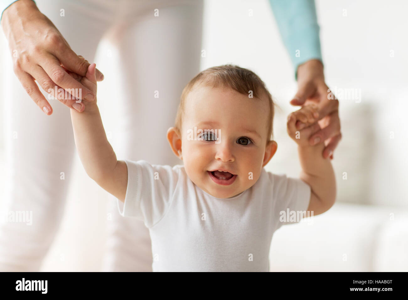 happy baby learning to walk with mother help Stock Photo - Alamy