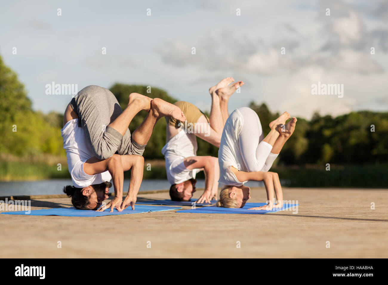people making yoga in crane pose outdoors Stock Photo - Alamy