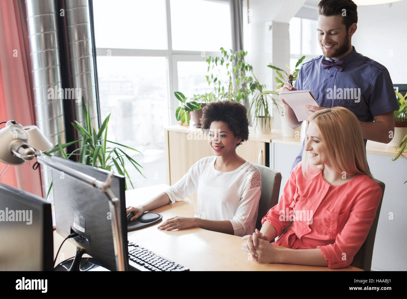 happy creative team with computer in office Stock Photo - Alamy