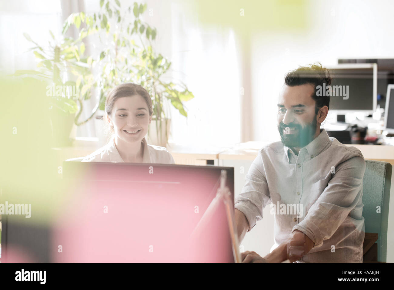 happy creative team with computer in office Stock Photo - Alamy