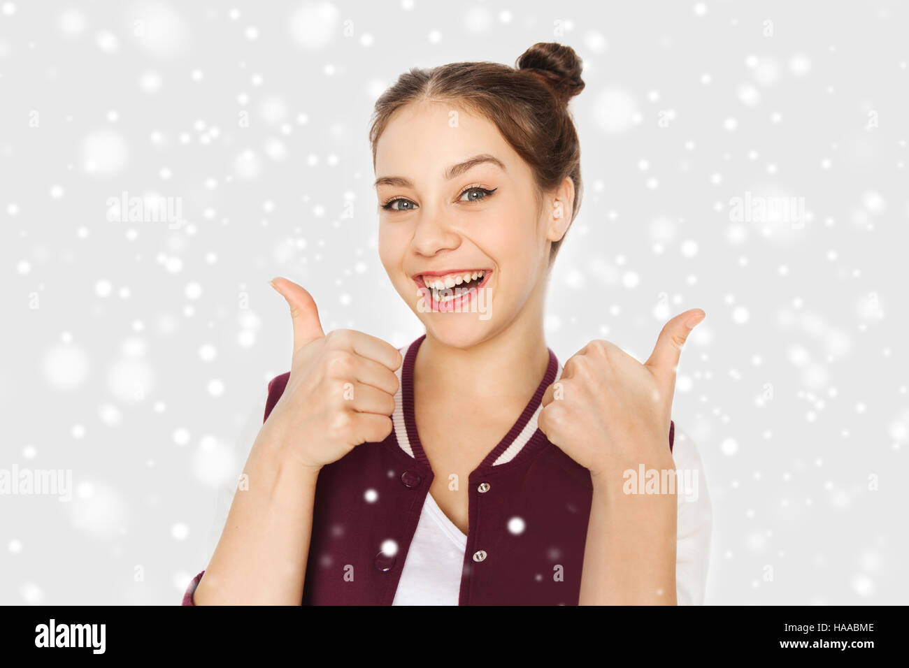 happy teenage girl showing thumbs up over snow Stock Photo - Alamy