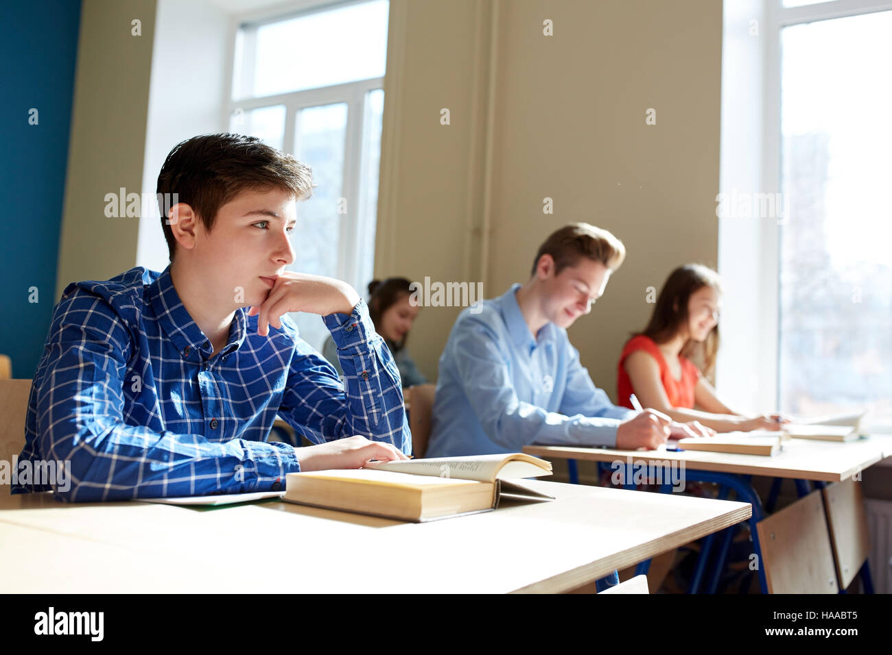 group of students with books writing school test Stock Photo - Alamy
