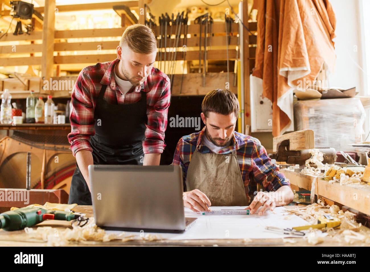 carpenters with laptop and blueprint at workshop Stock Photo - Alamy