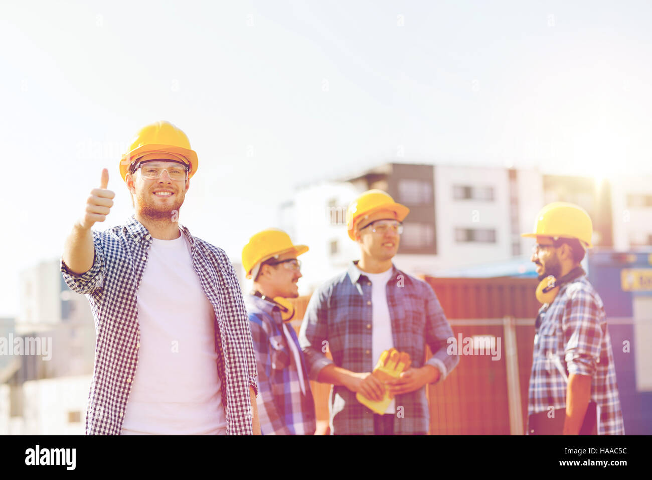 group of smiling builders in hardhats outdoors Stock Photo - Alamy