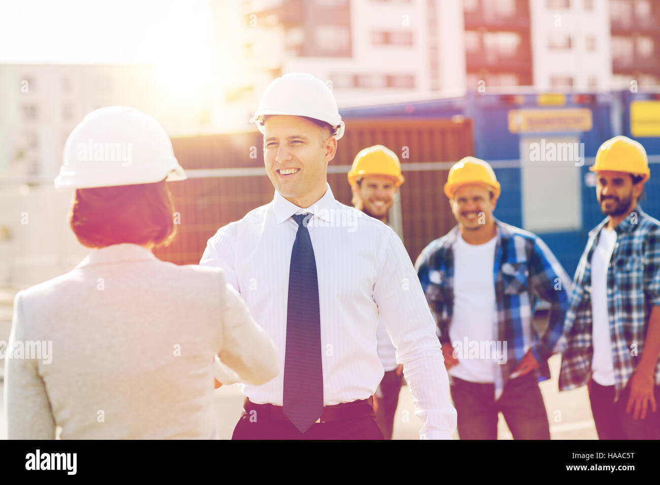 group of smiling builders in hardhats outdoors Stock Photo - Alamy