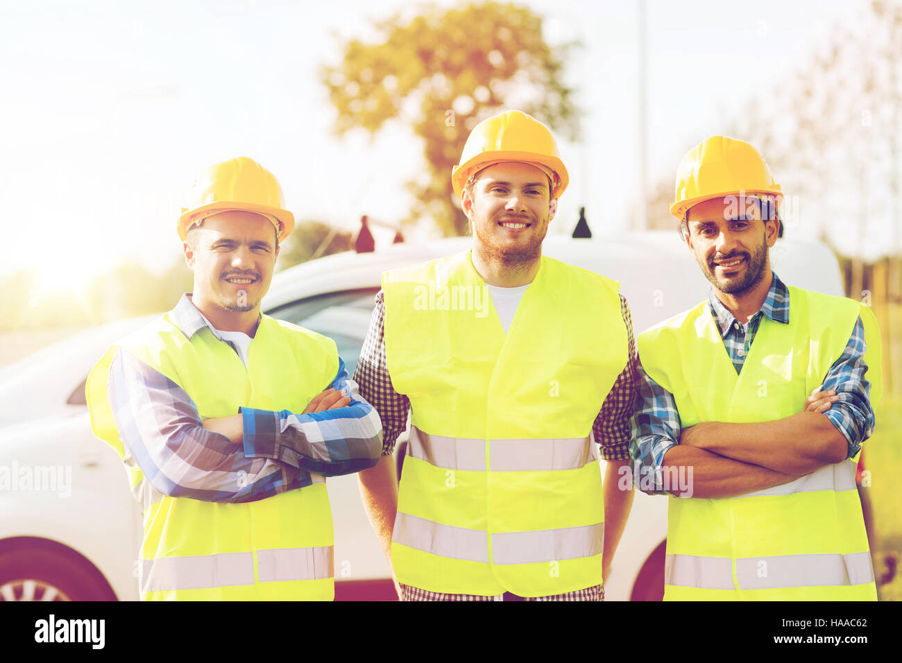 group of smiling builders in hardhats outdoors Stock Photo - Alamy