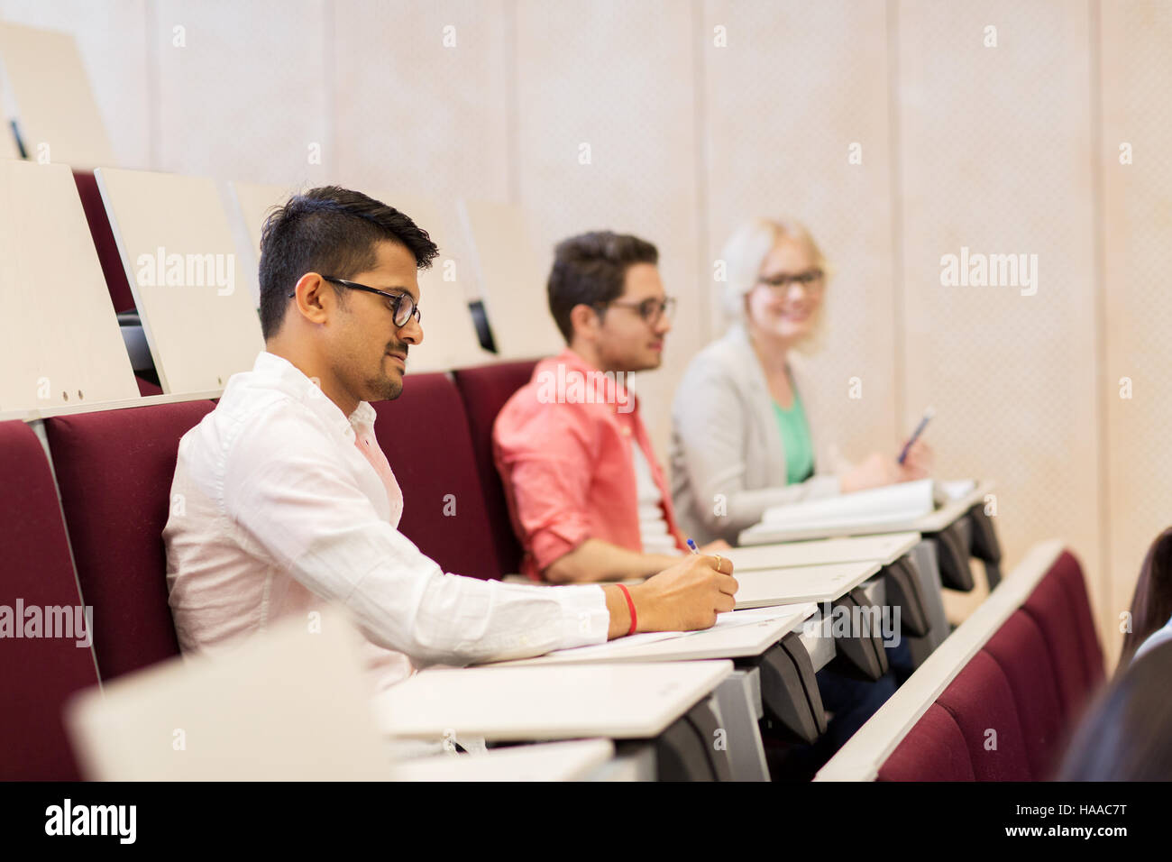 group of students with notebooks in lecture hall Stock Photo - Alamy