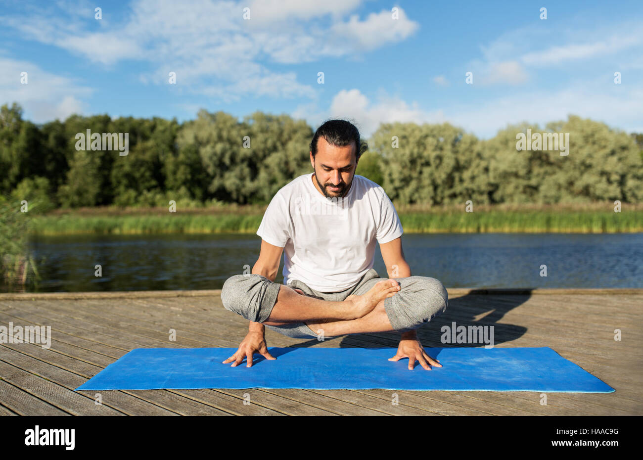 man making yoga in scale pose outdoors Stock Photo - Alamy