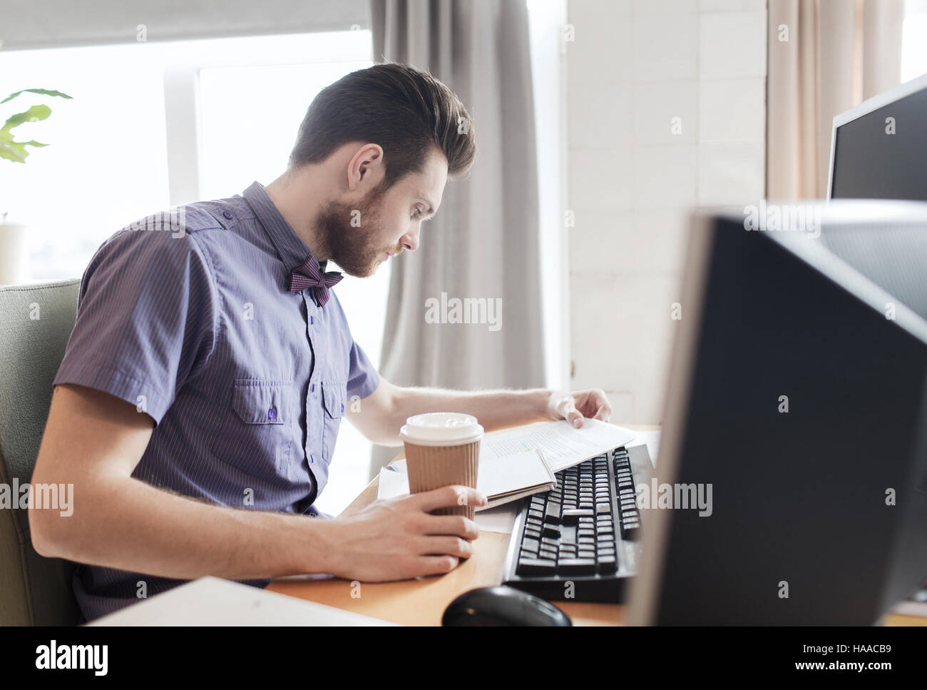creative male worker drinking coffee and reading Stock Photo - Alamy