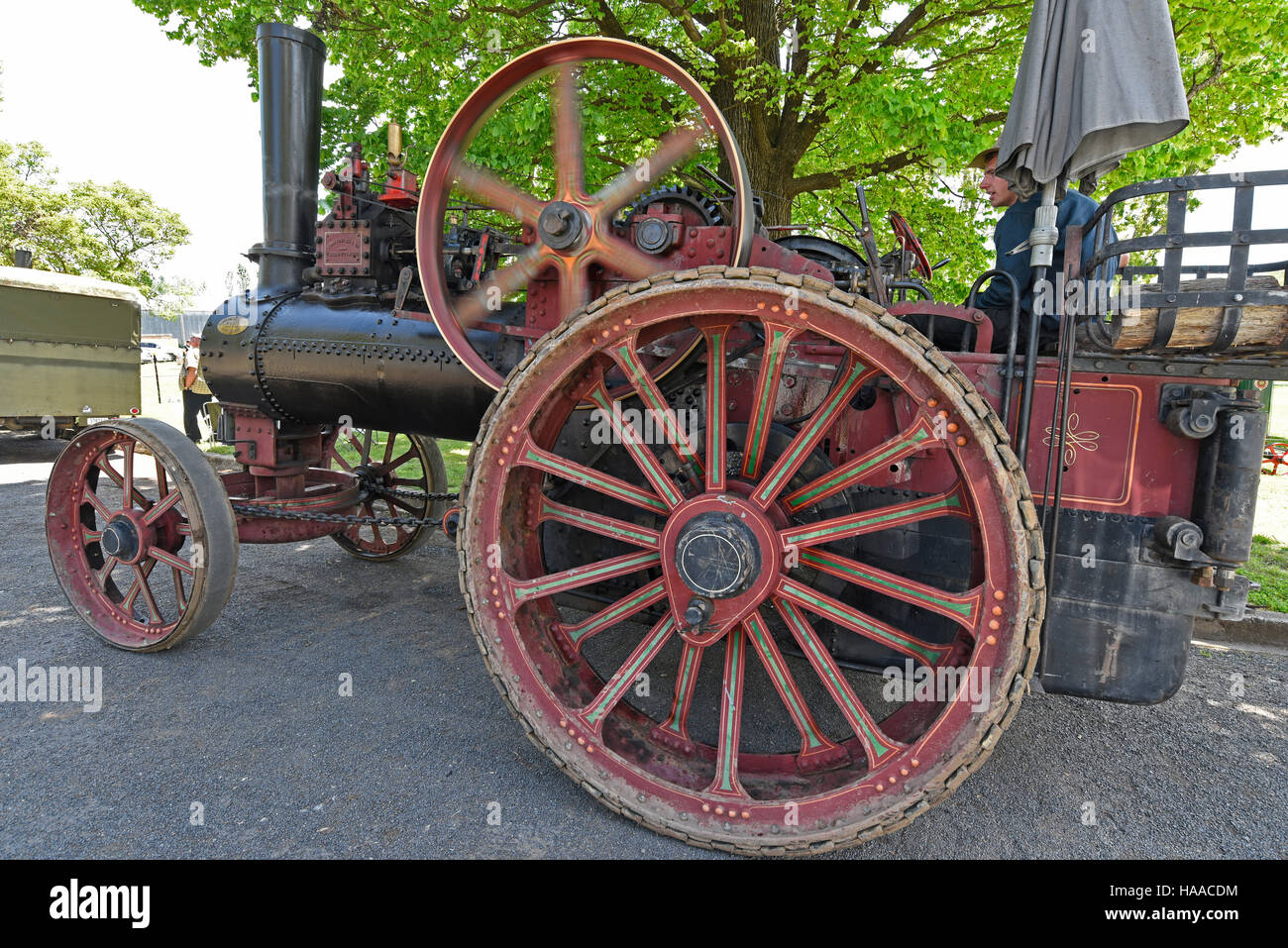 steam traction engine with young operator maintaining the machinery at ...