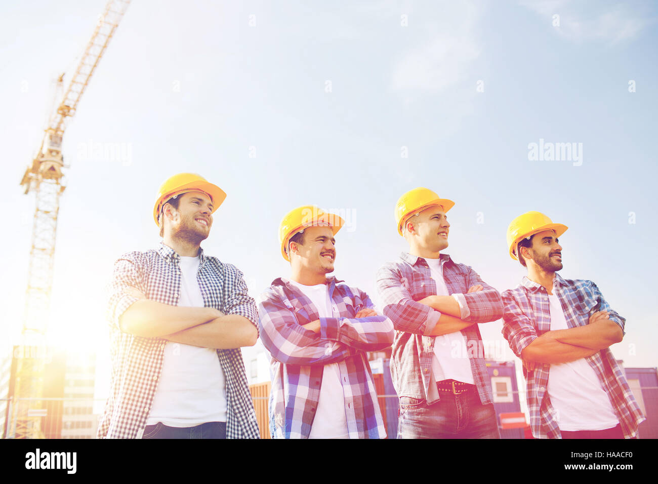 group of smiling builders in hardhats outdoors Stock Photo - Alamy