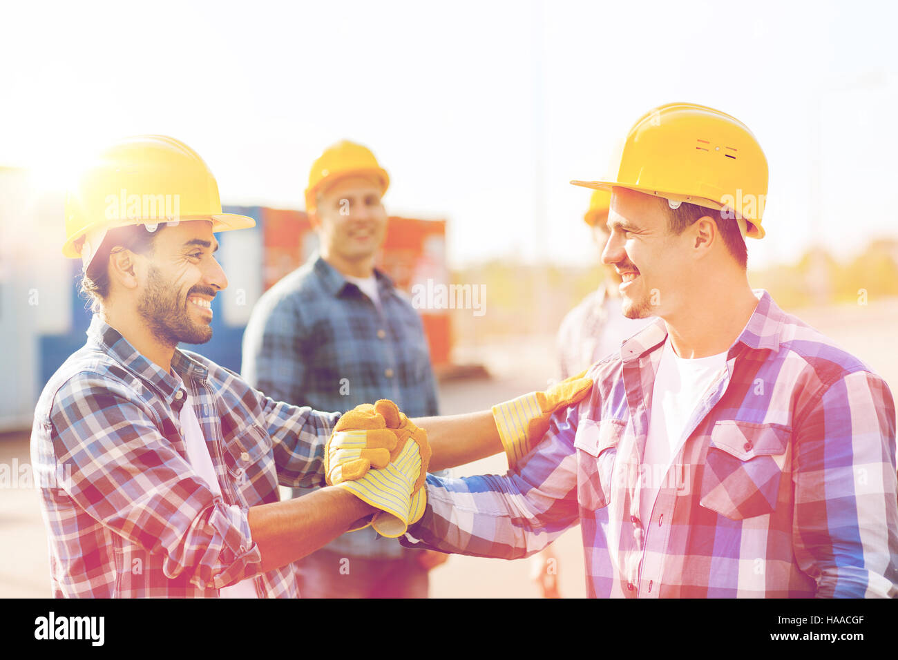 group of smiling builders in hardhats outdoors Stock Photo - Alamy
