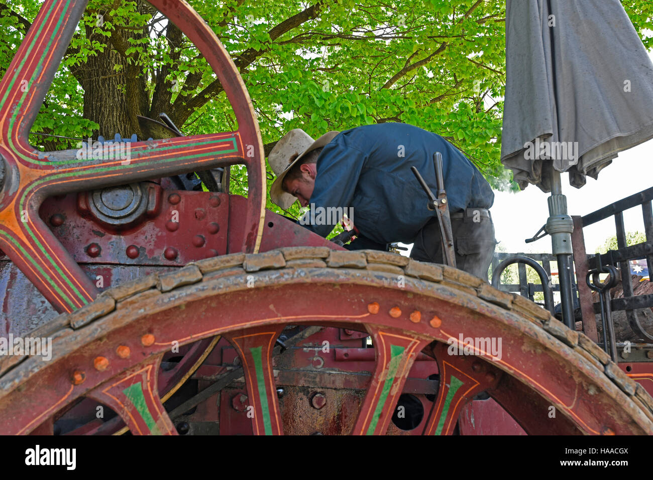 steam traction engine with young operator maintaining the machinery at ...