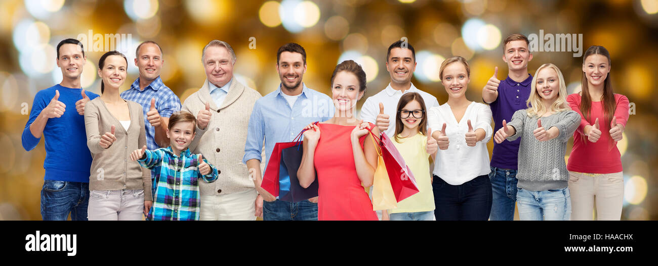 happy people with shopping bags showing thumbs up Stock Photo - Alamy