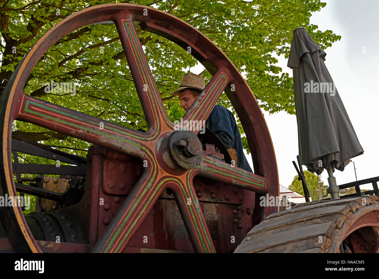 steam traction engine with young operator maintaining the machinery at ...