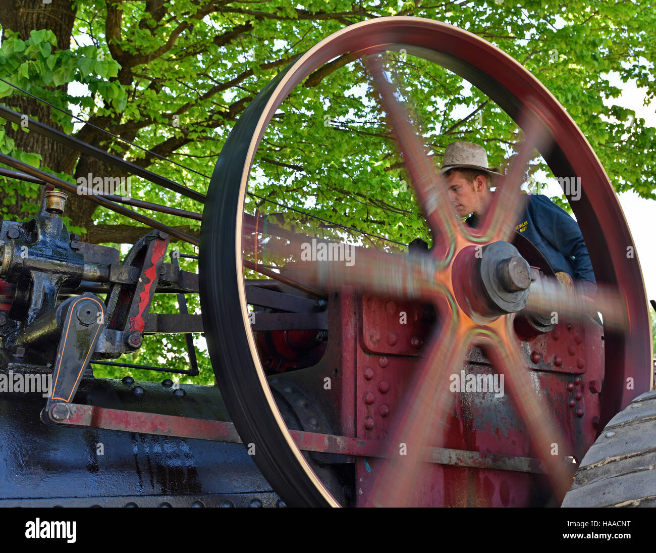 steam traction engine with young operator maintaining the machinery at ...
