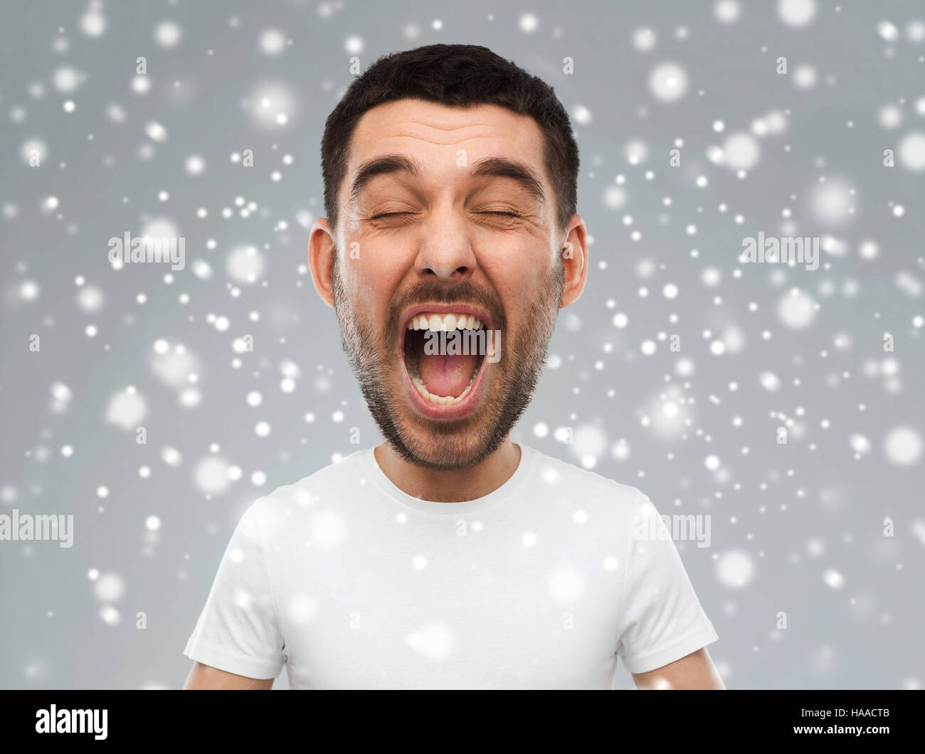 crazy shouting man in t-shirt over snow background Stock Photo - Alamy