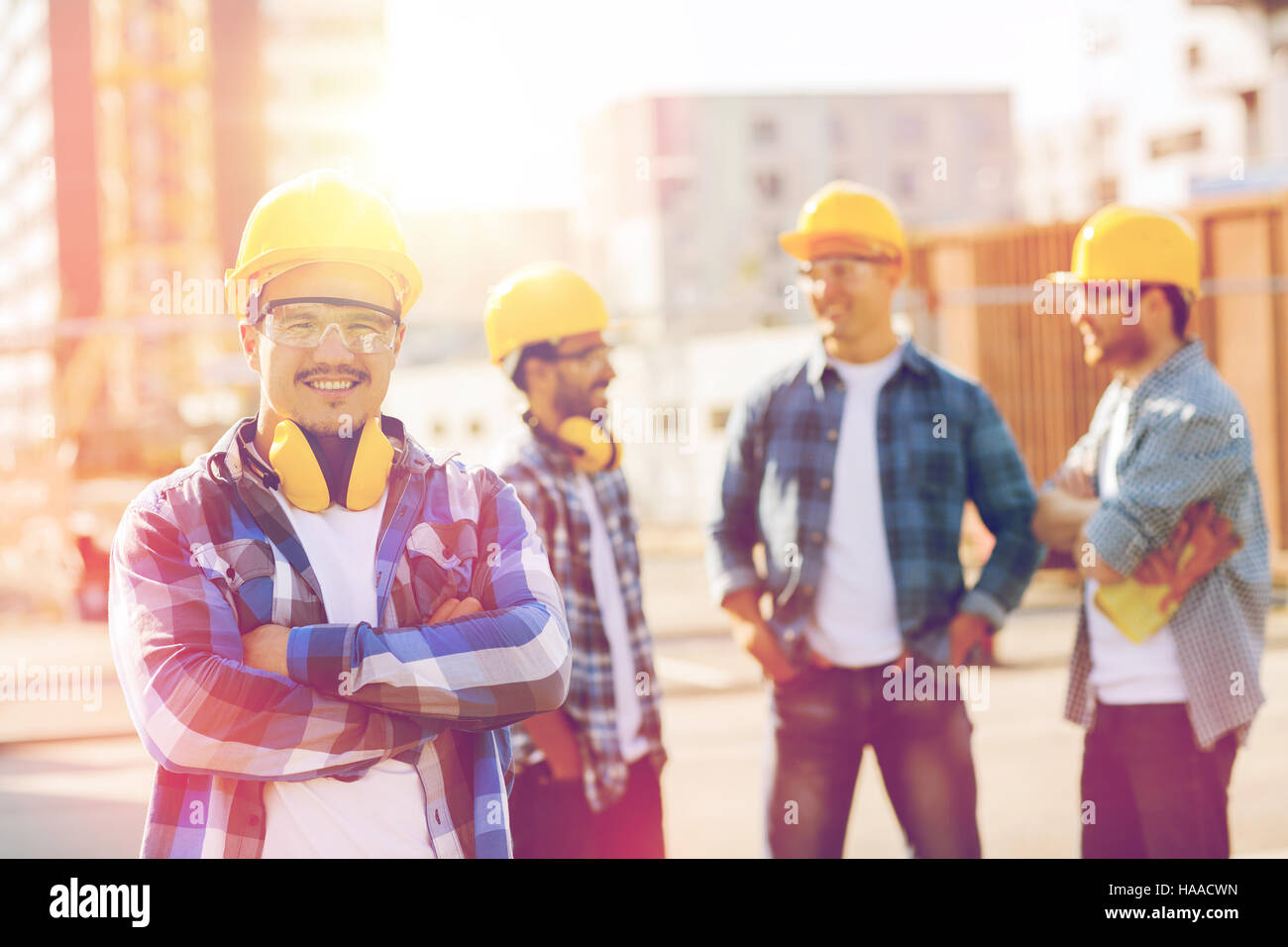 group of smiling builders in hardhats outdoors Stock Photo - Alamy