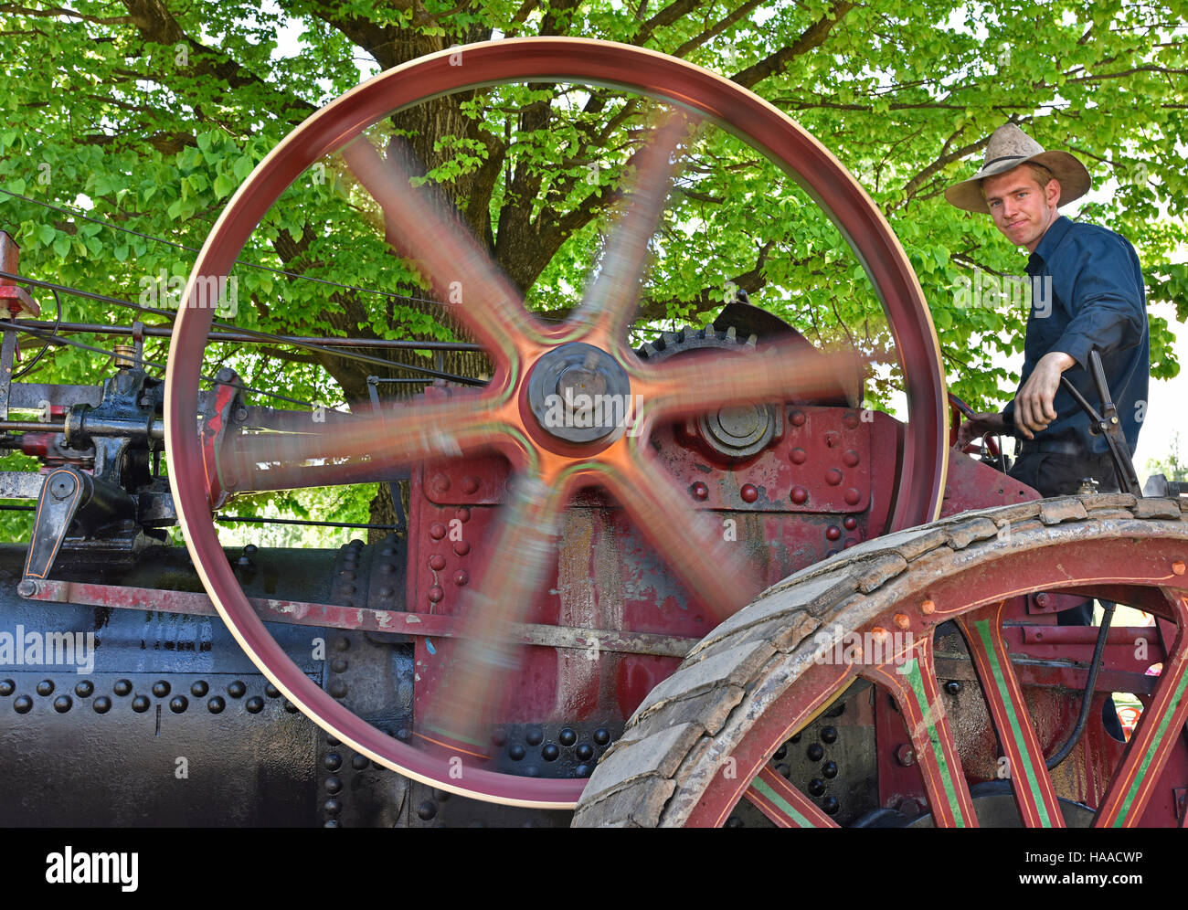 steam traction engine with young operator maintaining the machinery at ...