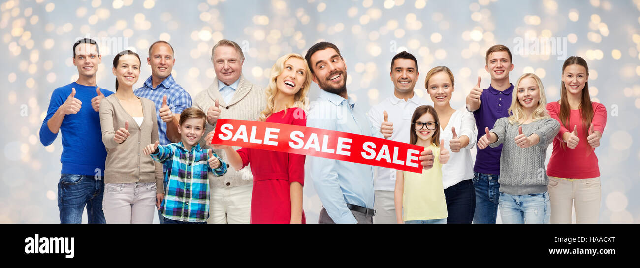 happy people with sale sign showing thumbs up Stock Photo - Alamy