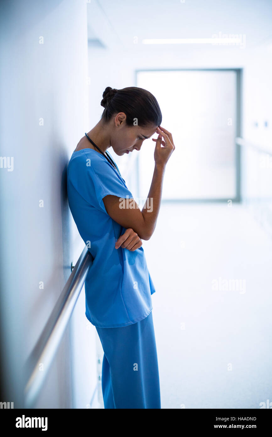Sad nurse standing in corridor Stock Photo - Alamy