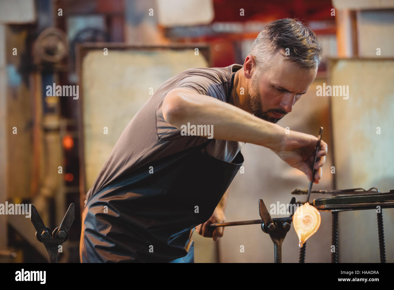 Glassblower shaping a molten glass Stock Photo - Alamy