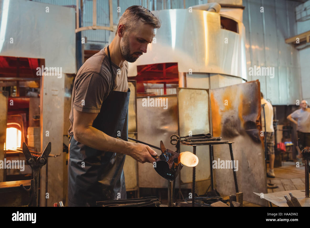 Glassblower forming and shaping a molten glass Stock Photo - Alamy