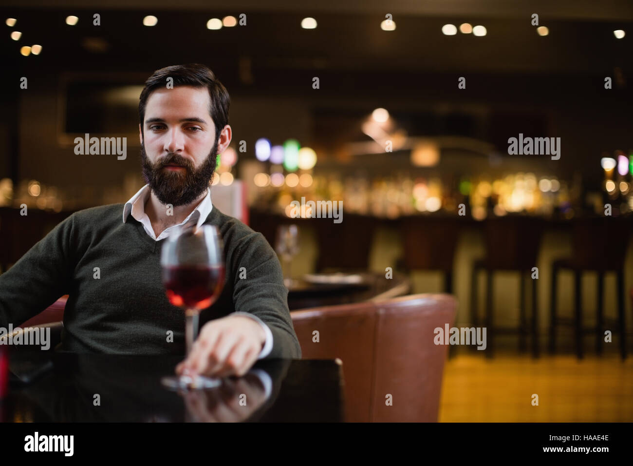 Man looking at glass of red wine Stock Photo - Alamy