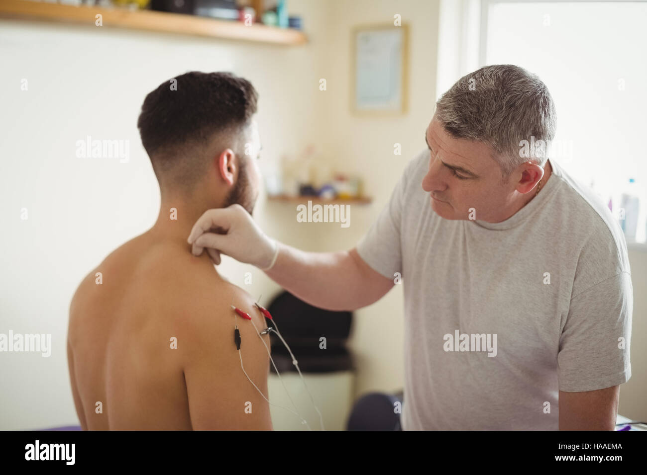 Physiotherapist performing electro dry needling on patient Stock Photo ...