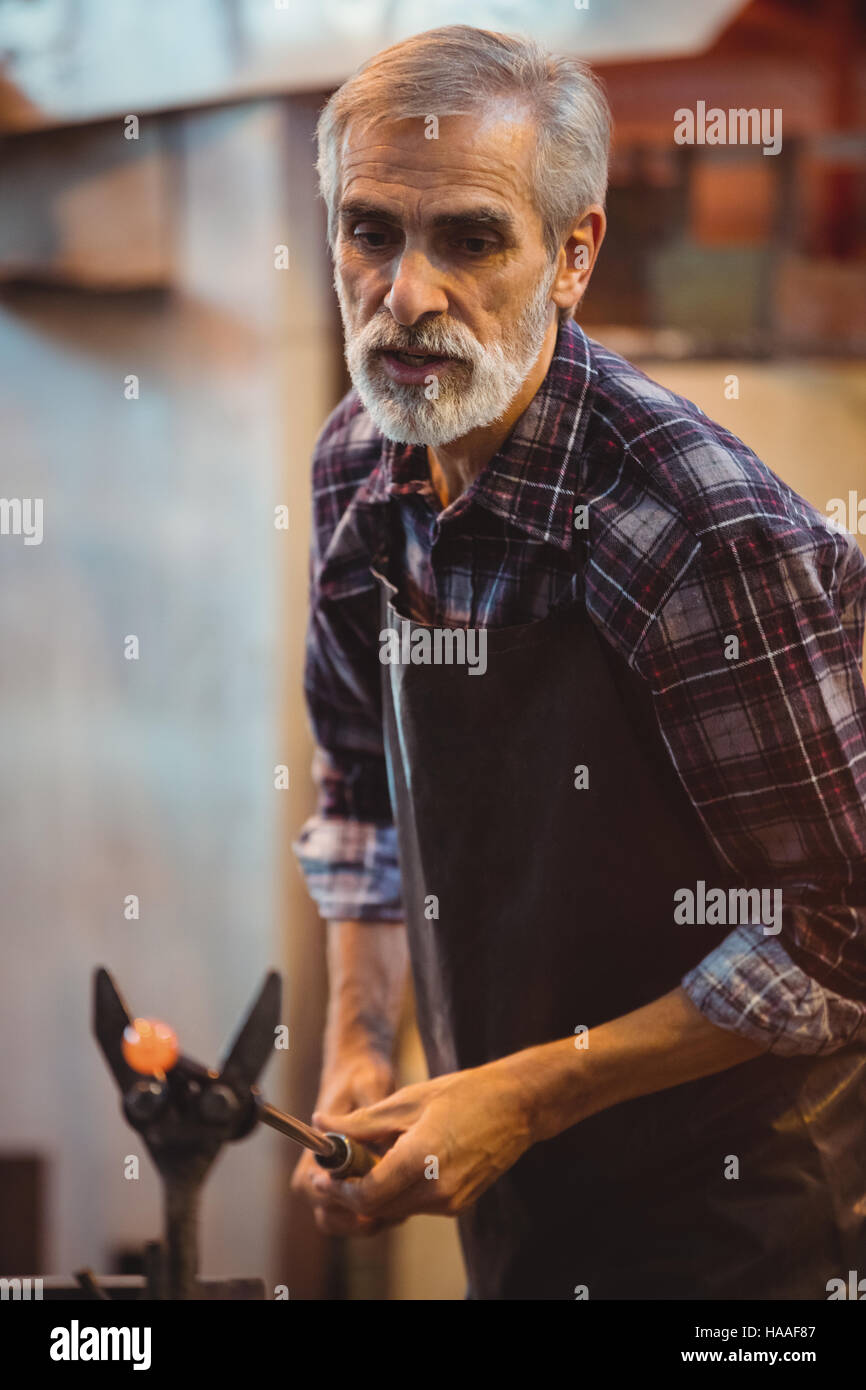 Glassblower shaping a molten glass Stock Photo - Alamy